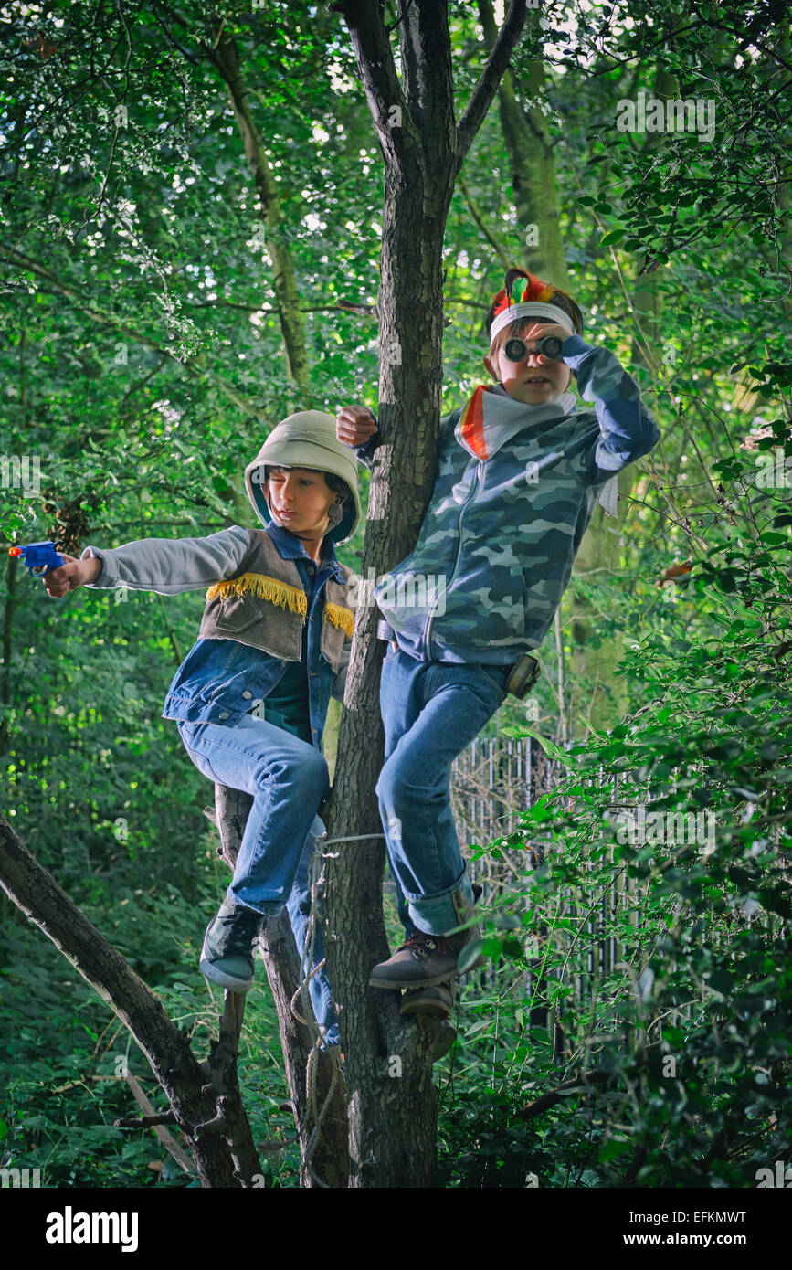 Boys dressed up looking out from forest trees Stock Photo - Alamy