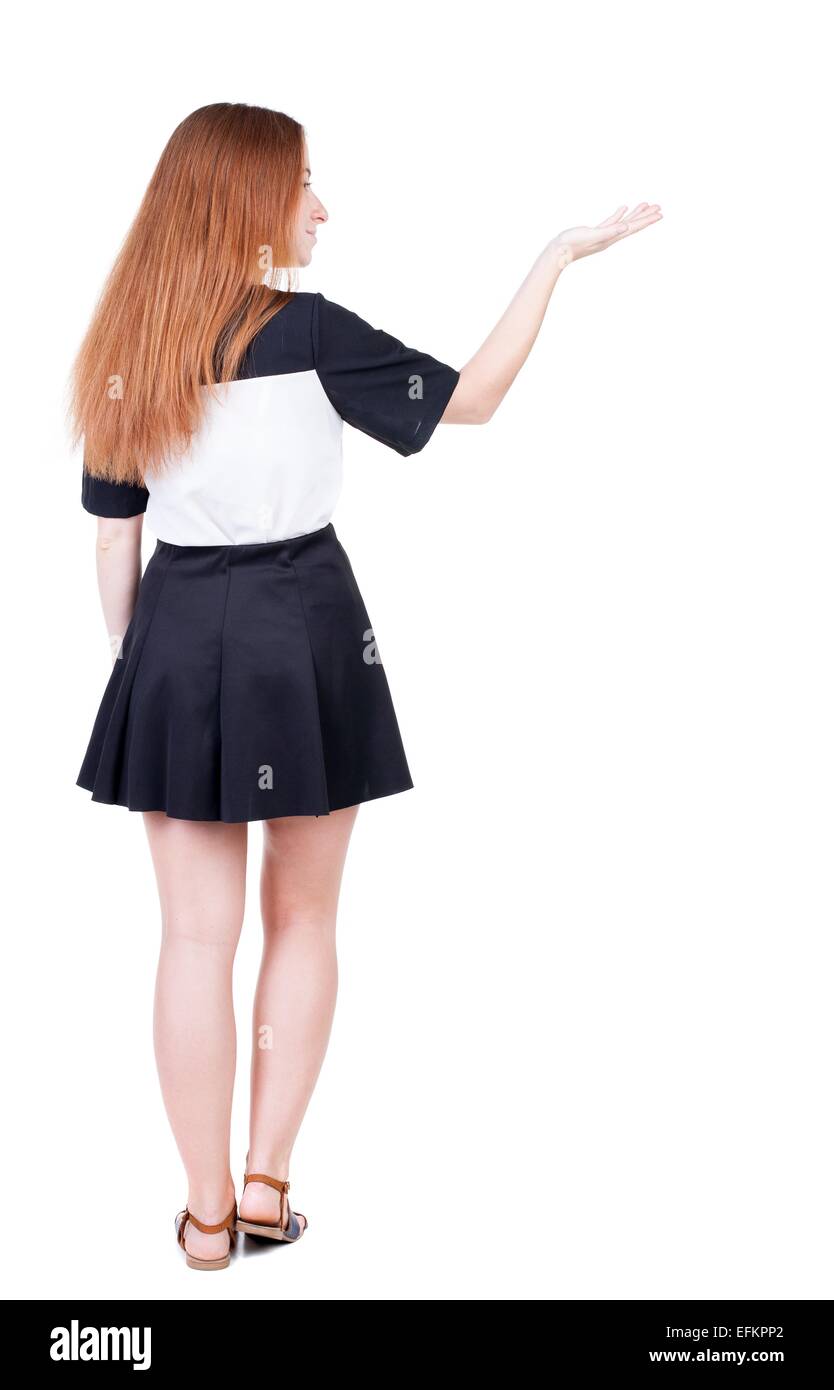 Back view of Beautiful woman in dress looking at wall and Holds hand up ...