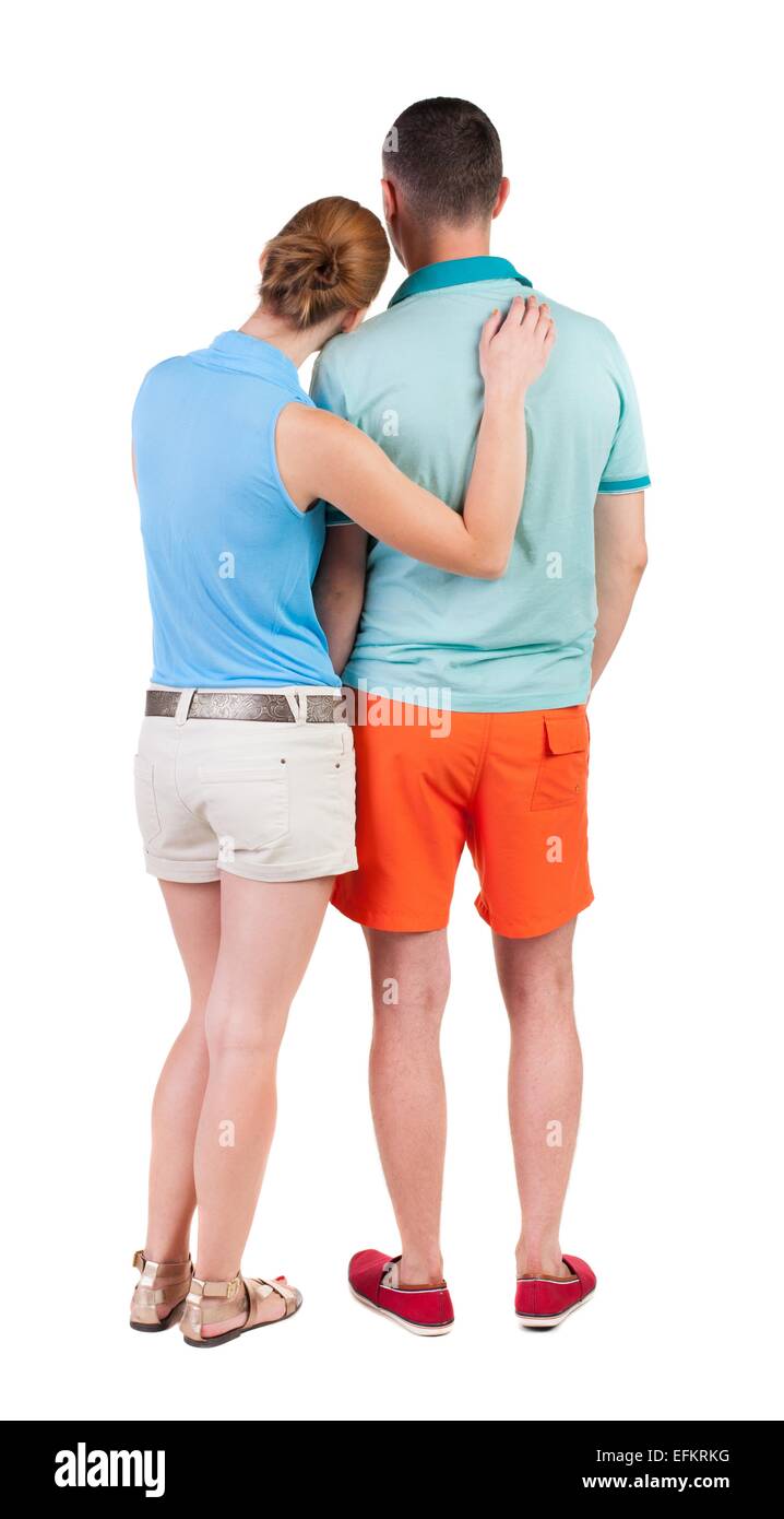 Back view of young embracing couple in shorts hug and look. friendly ...
