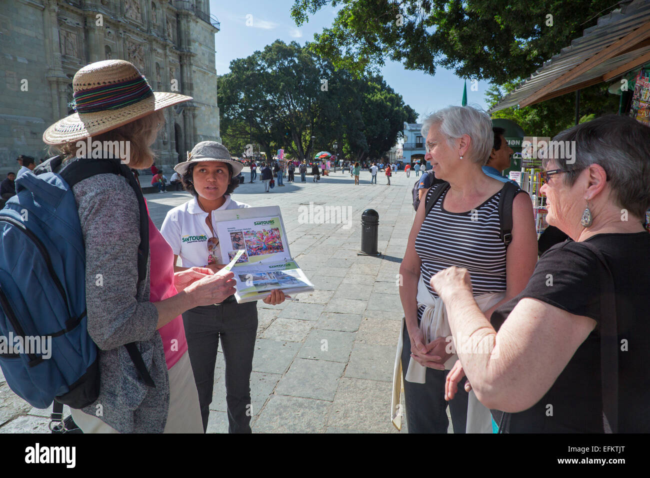 Oaxaca, Mexico - A worker for a tour operator talks to tourists in the ...