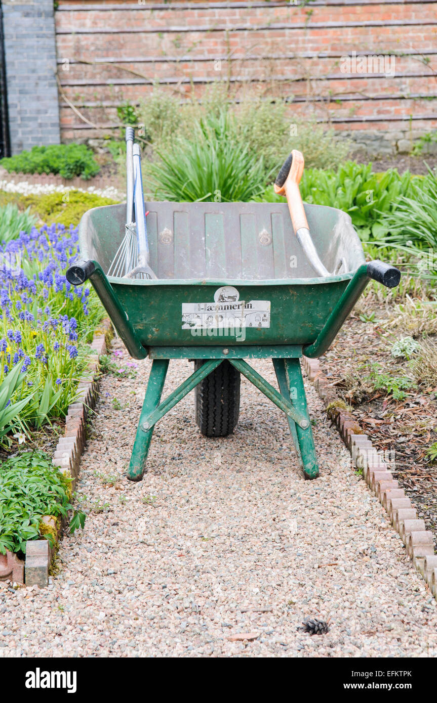 Wheelbarrow with gardening tools Stock Photo - Alamy