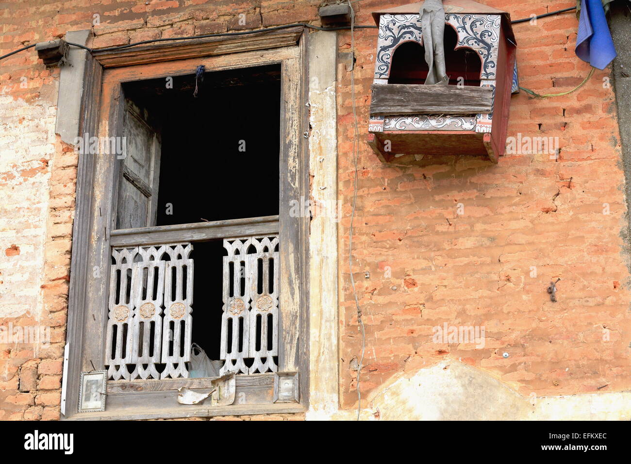 Old wooden window with cross arms and decorated bird cage hanging from ...