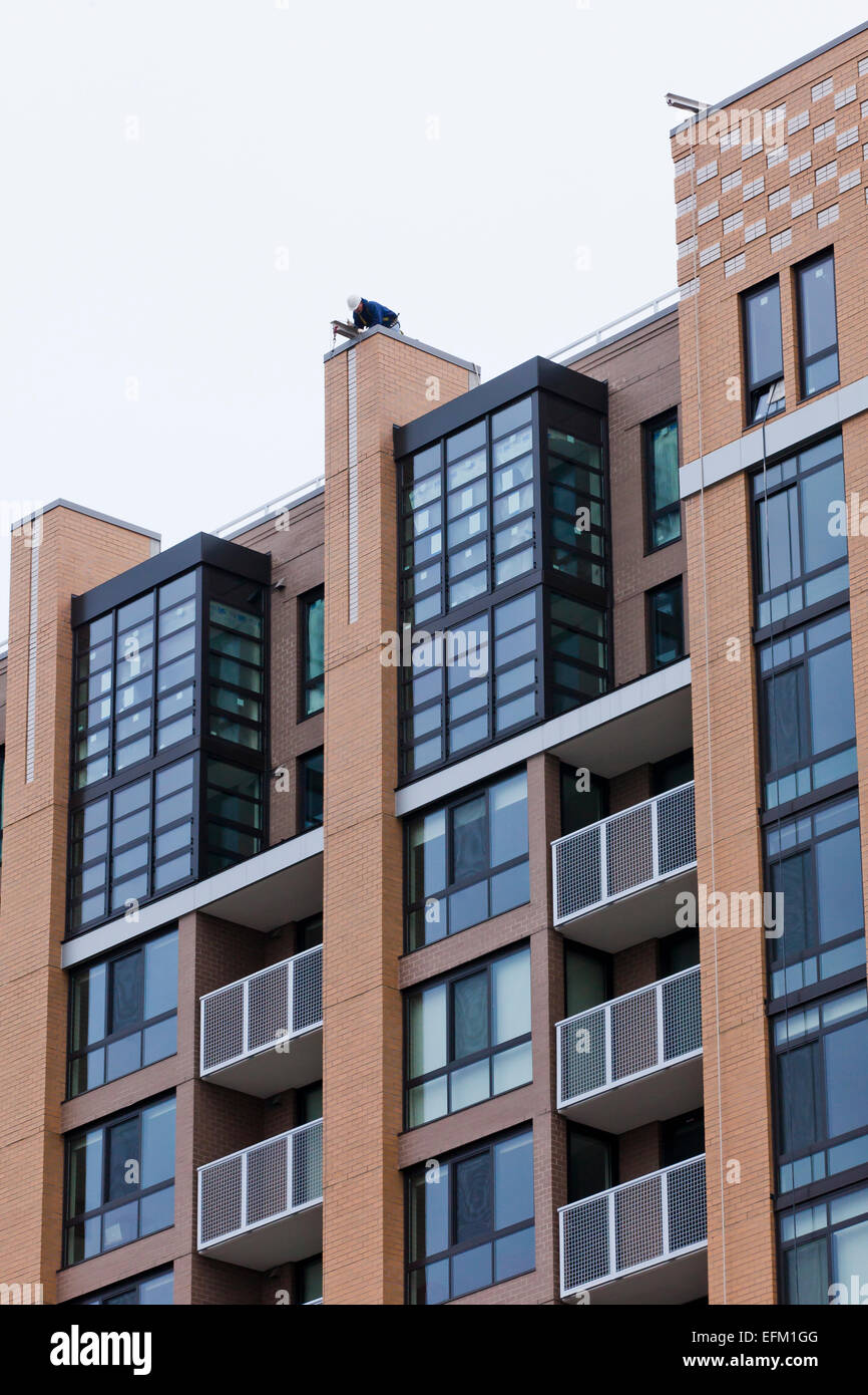 Man working on ledge atop a highrise building - USA Stock Photo - Alamy