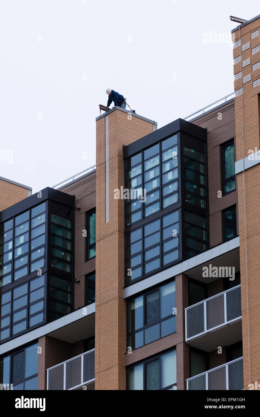 Man working on ledge atop a highrise building - USA Stock Photo - Alamy