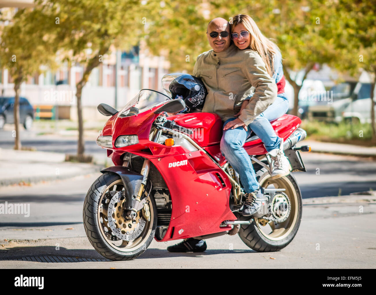 Couple with motorbike Stock Photo - Alamy