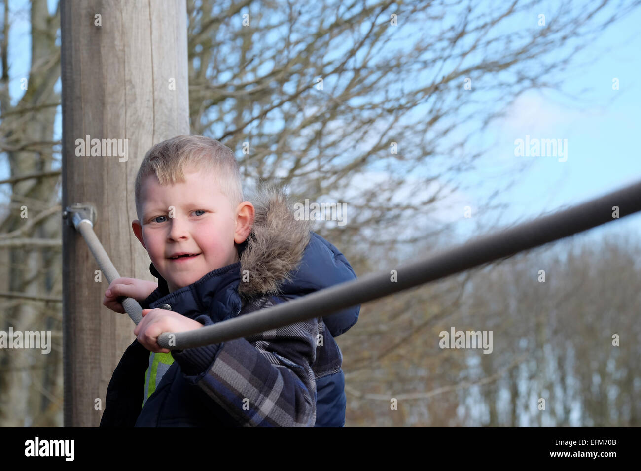 Boy playing on adventure playground Stock Photo - Alamy