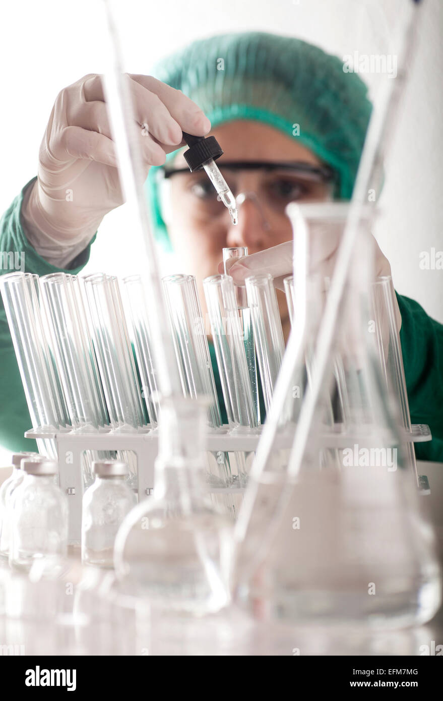 Closeup of a female scientist filling test tubes with pipette in ...