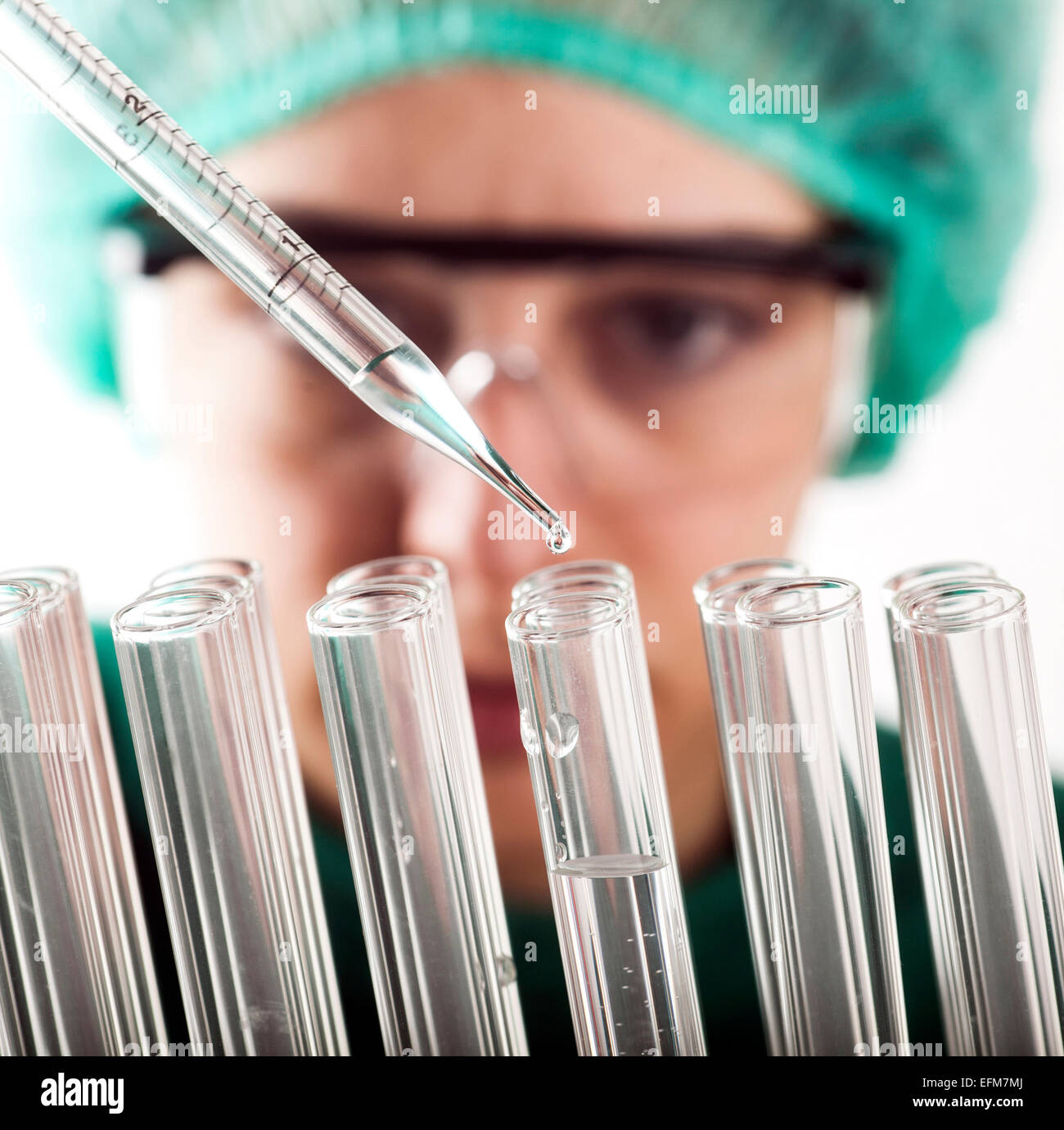Closeup of a female scientist filling test tubes with pipette in ...