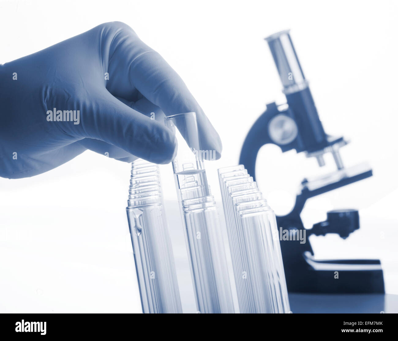 Closeup of glass test tubes and laboratory microscope on a white ...