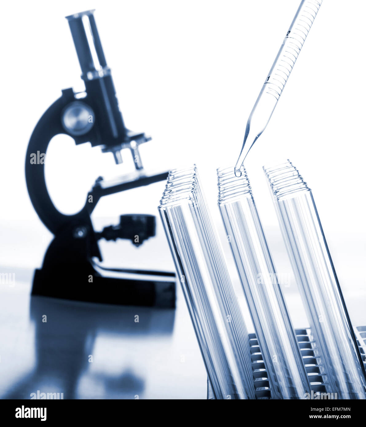 Closeup of glass test tubes and laboratory microscope on a white ...
