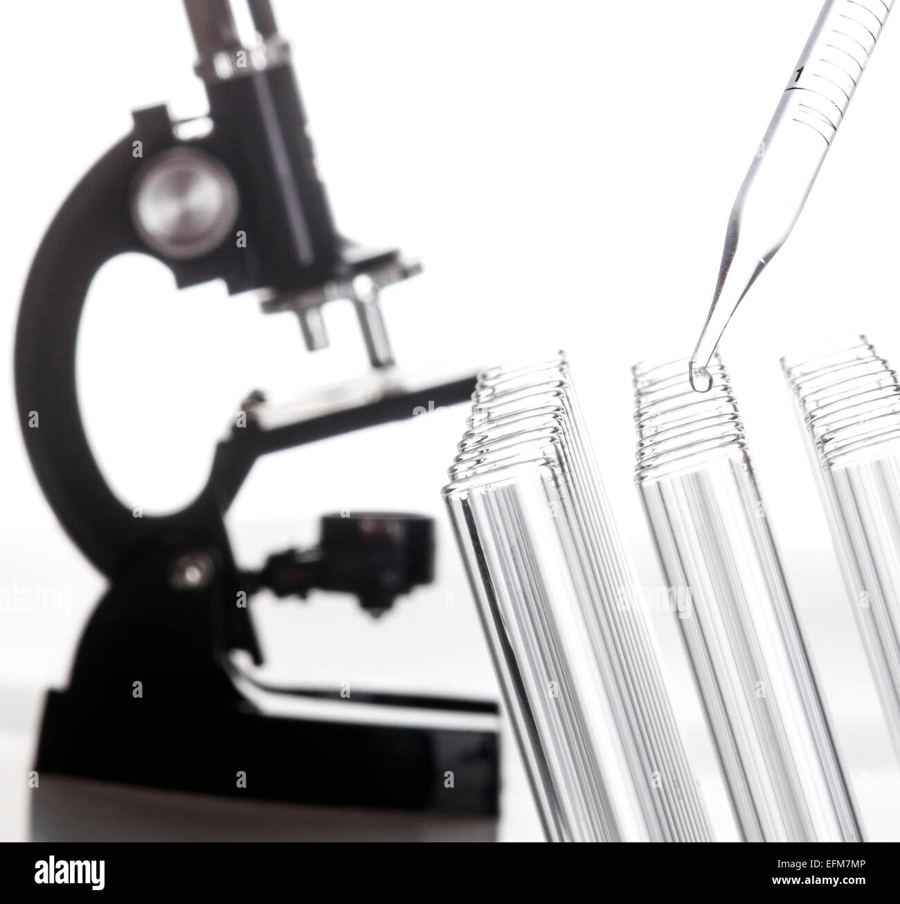 Closeup of glass test tubes and laboratory microscope on a white ...
