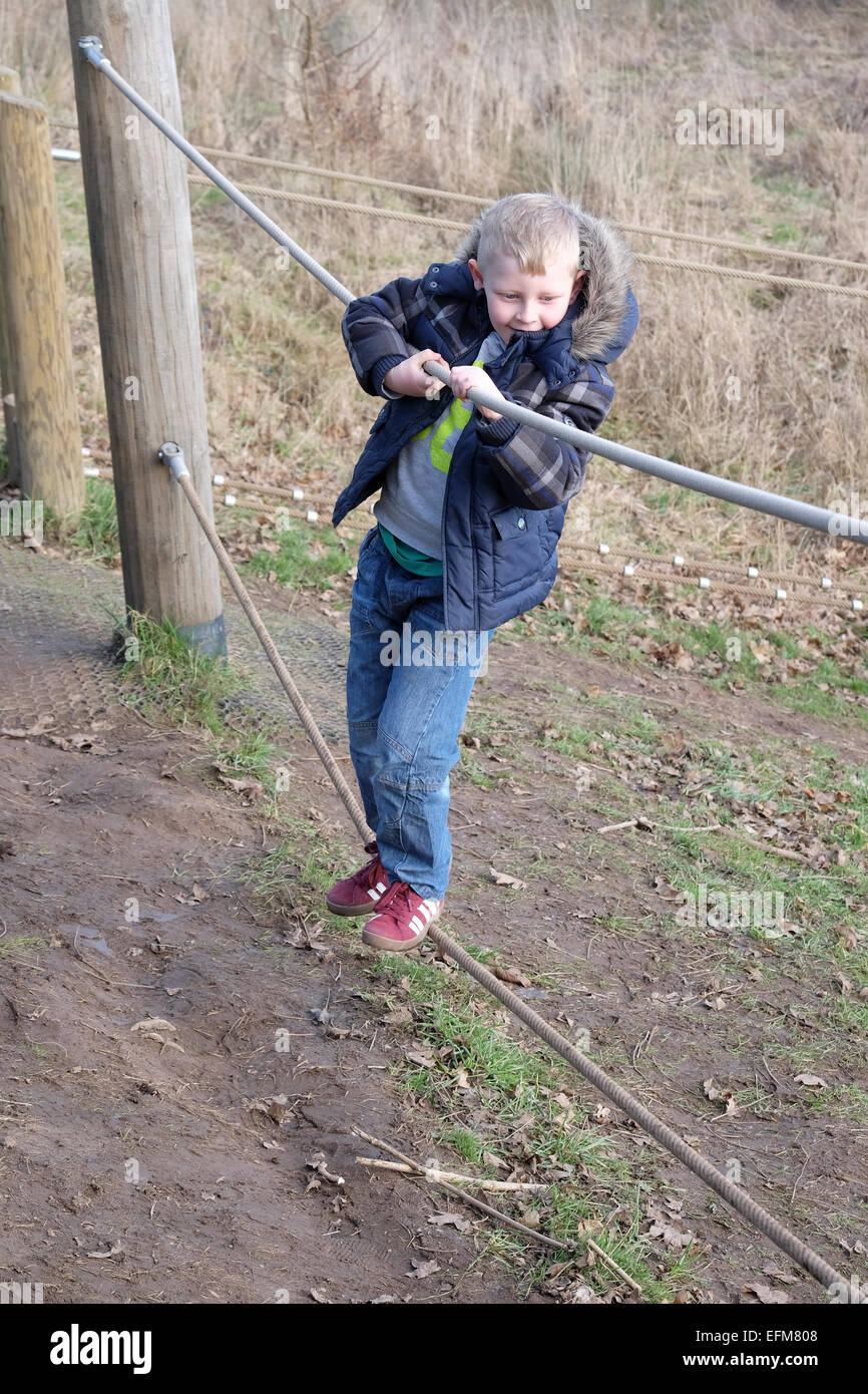 Boy on adventure playground balancing on ropes Stock Photo - Alamy