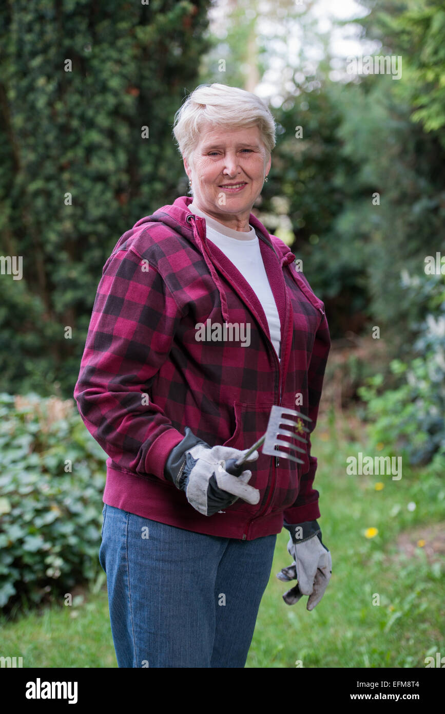 Woman using garden rake hi-res stock photography and images - Alamy