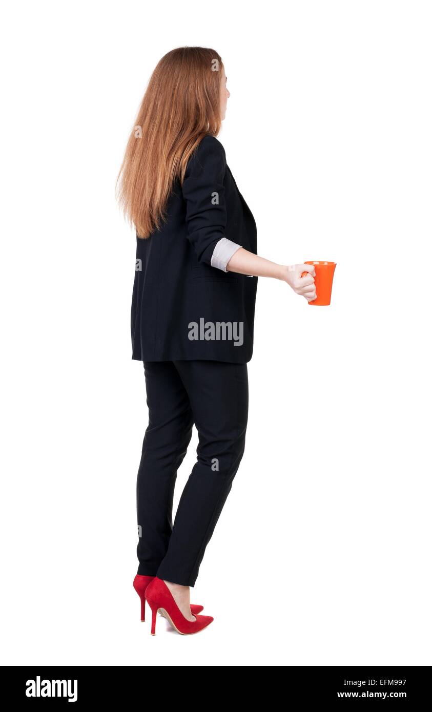 Rear view of a young business woman drinking coffee or tea while ...