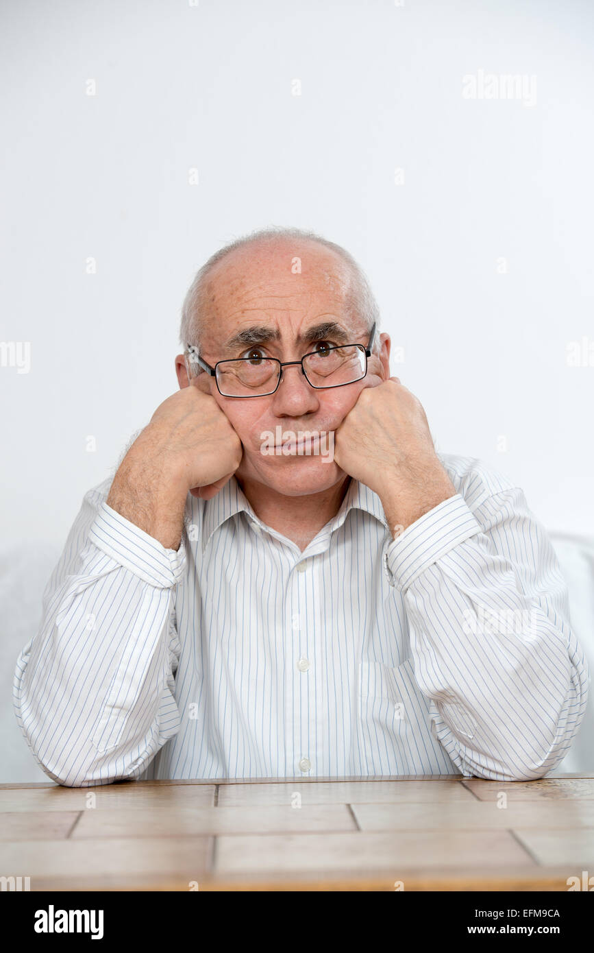 old man, wearing glasses, thinking and holding his head Stock Photo - Alamy