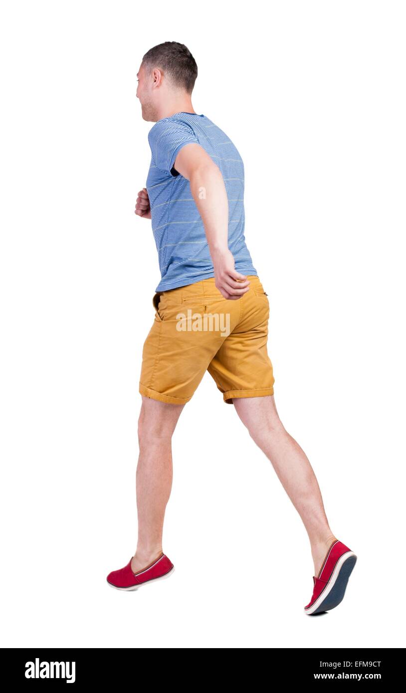 Back view of running man in t-shirt and shorts. Walking guy in motion ...