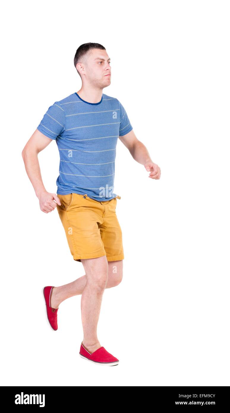 Back view of running man in t-shirt and shorts. Walking guy in motion ...