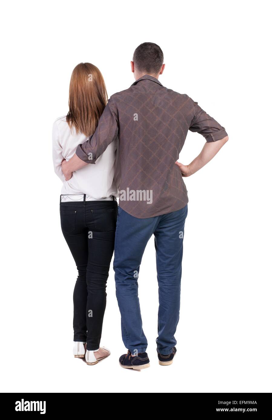 Back view of young embracing couple (man and woman) hug and look into ...