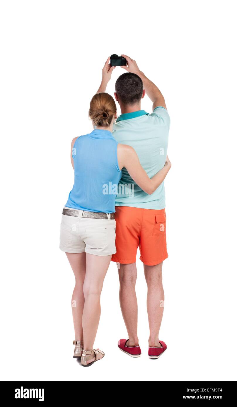 Back view of couple photographing. Tourists take pictures of the family ...