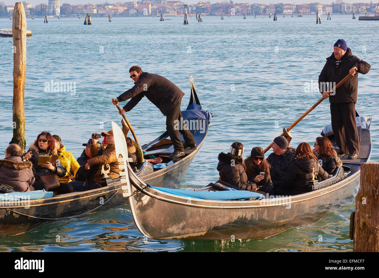Two gondoliers rowing full gondolas on the lagoon Venice Veneto Italy ...