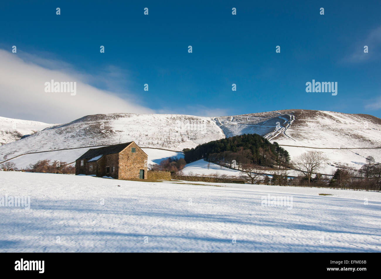 A stone barn in a snowy winter landscape in the vale of Edale, Peak ...