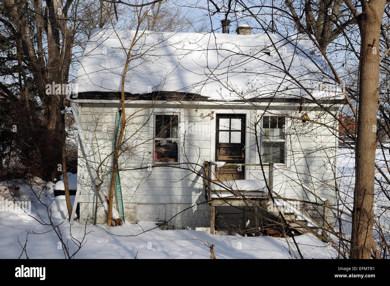 Winter bound run down cottage along the banks of the Fox River in ...