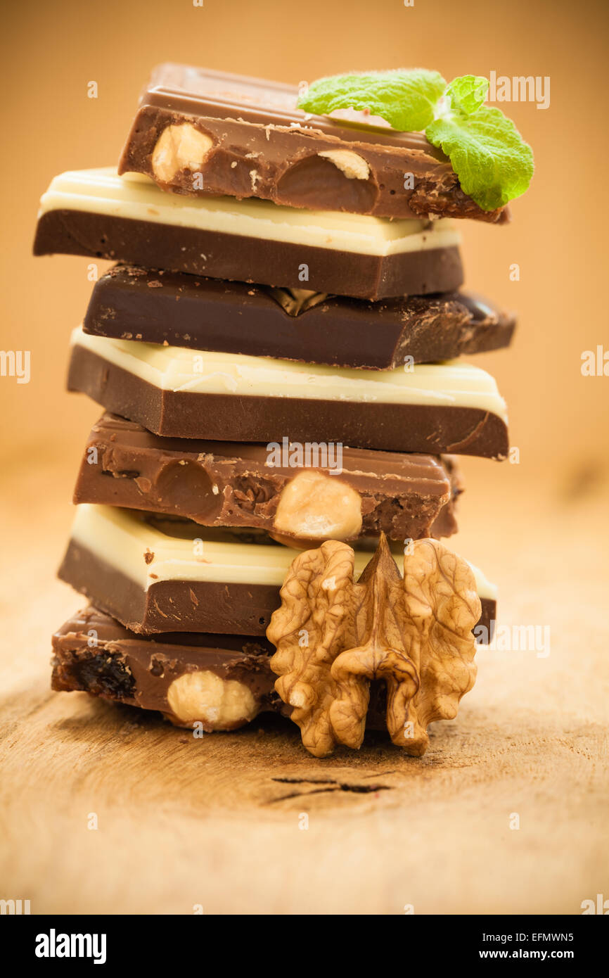 Closeup stack of different sorts chocolate pieces and walnut. Variety ...