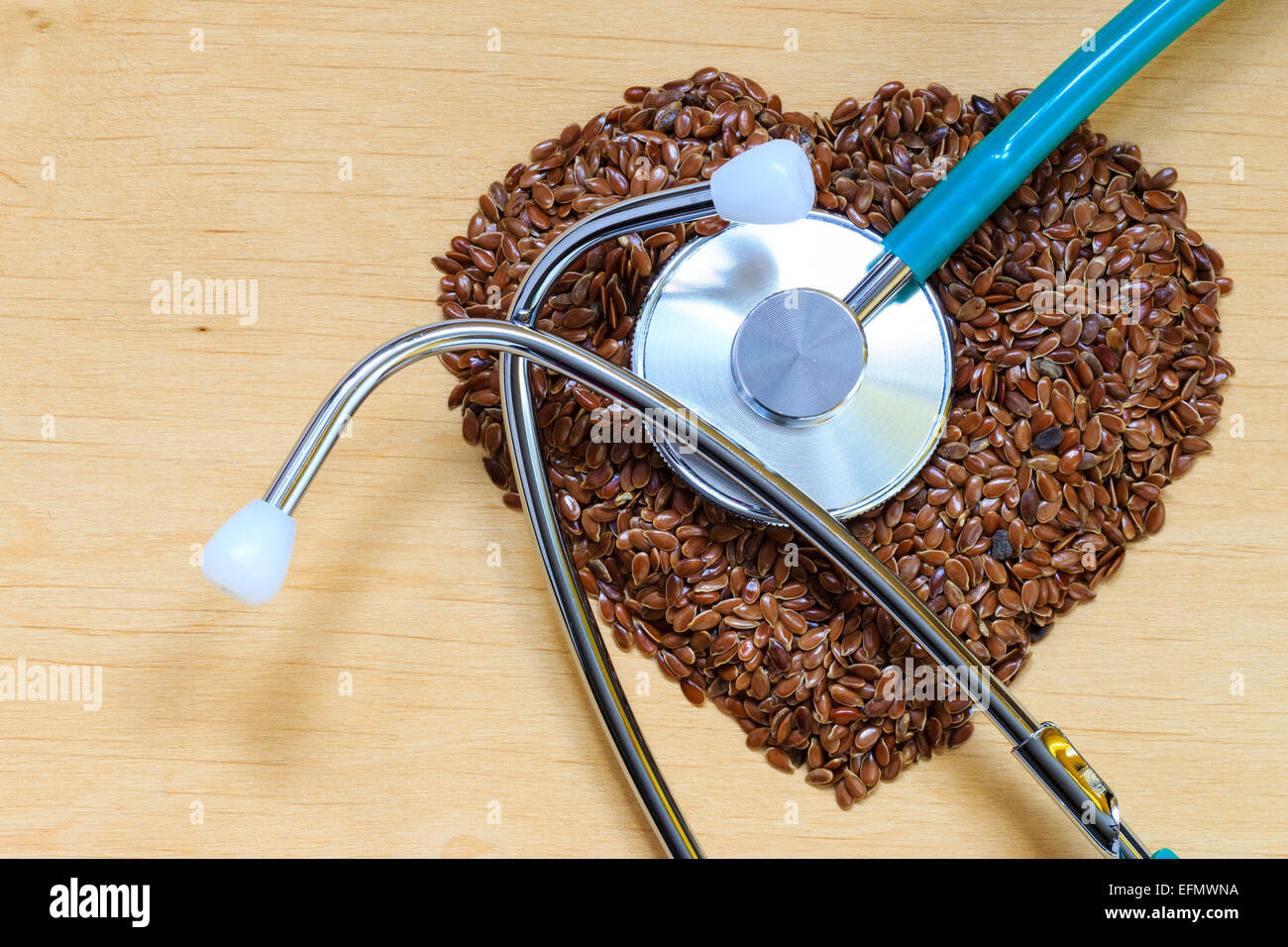 Diet healthcare and checkup concept. Raw flax seeds linseed heart shaped and stethoscope ...