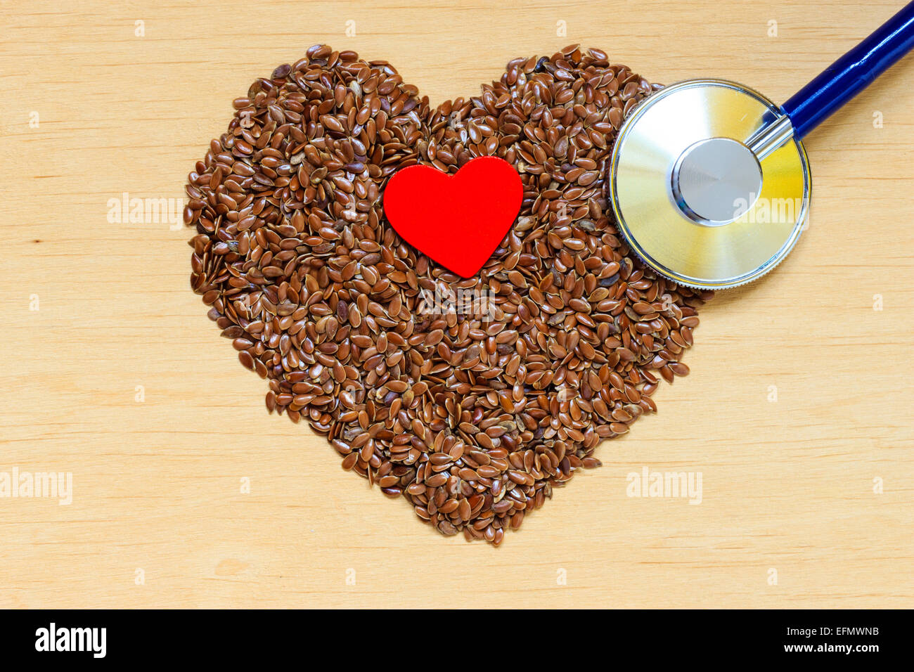Diet healthcare and checkup concept. Raw flax seeds linseed heart shaped and stethoscope ...