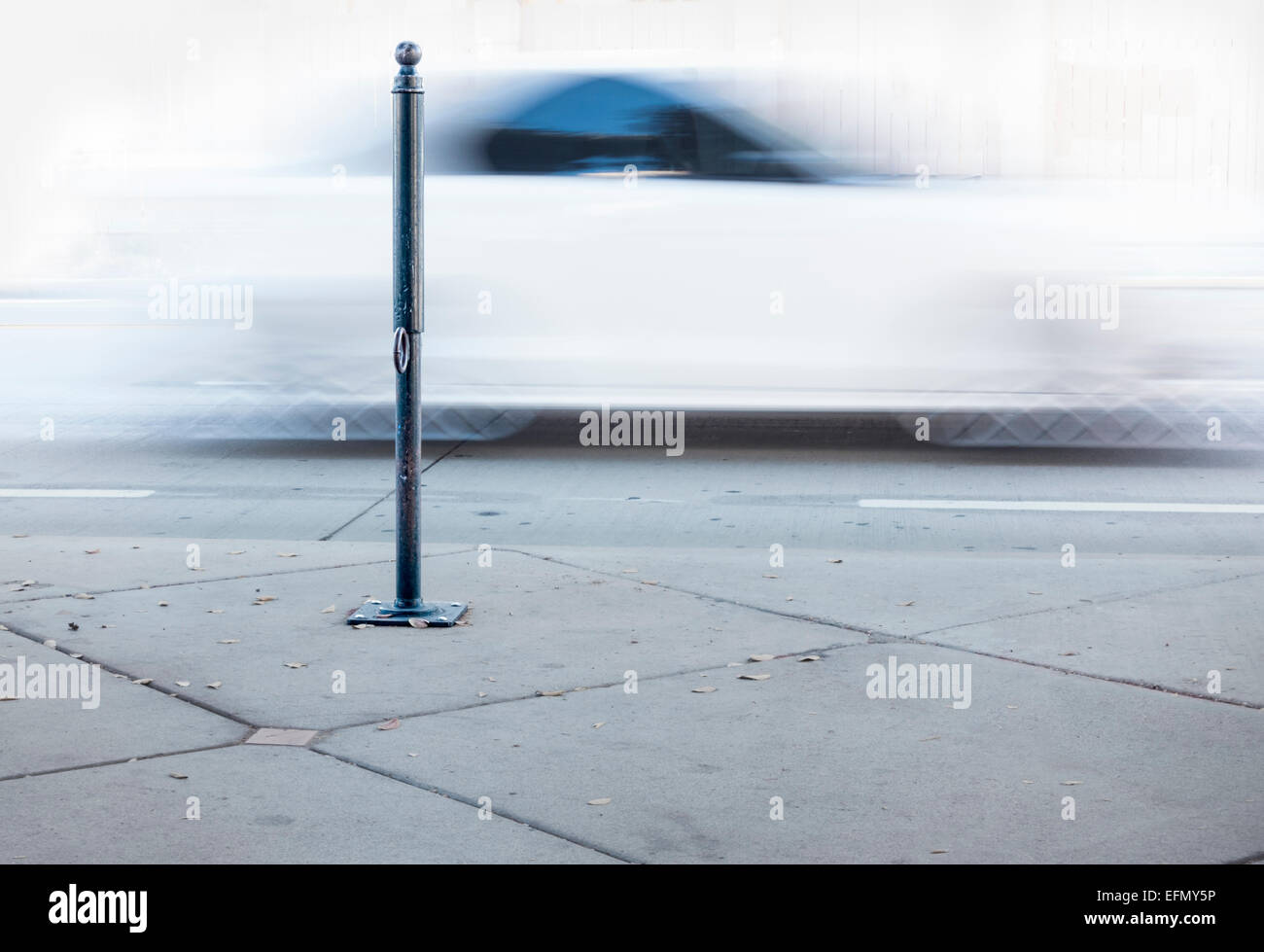 Motion blurry white car moving fast with foreground in sharp focus ...