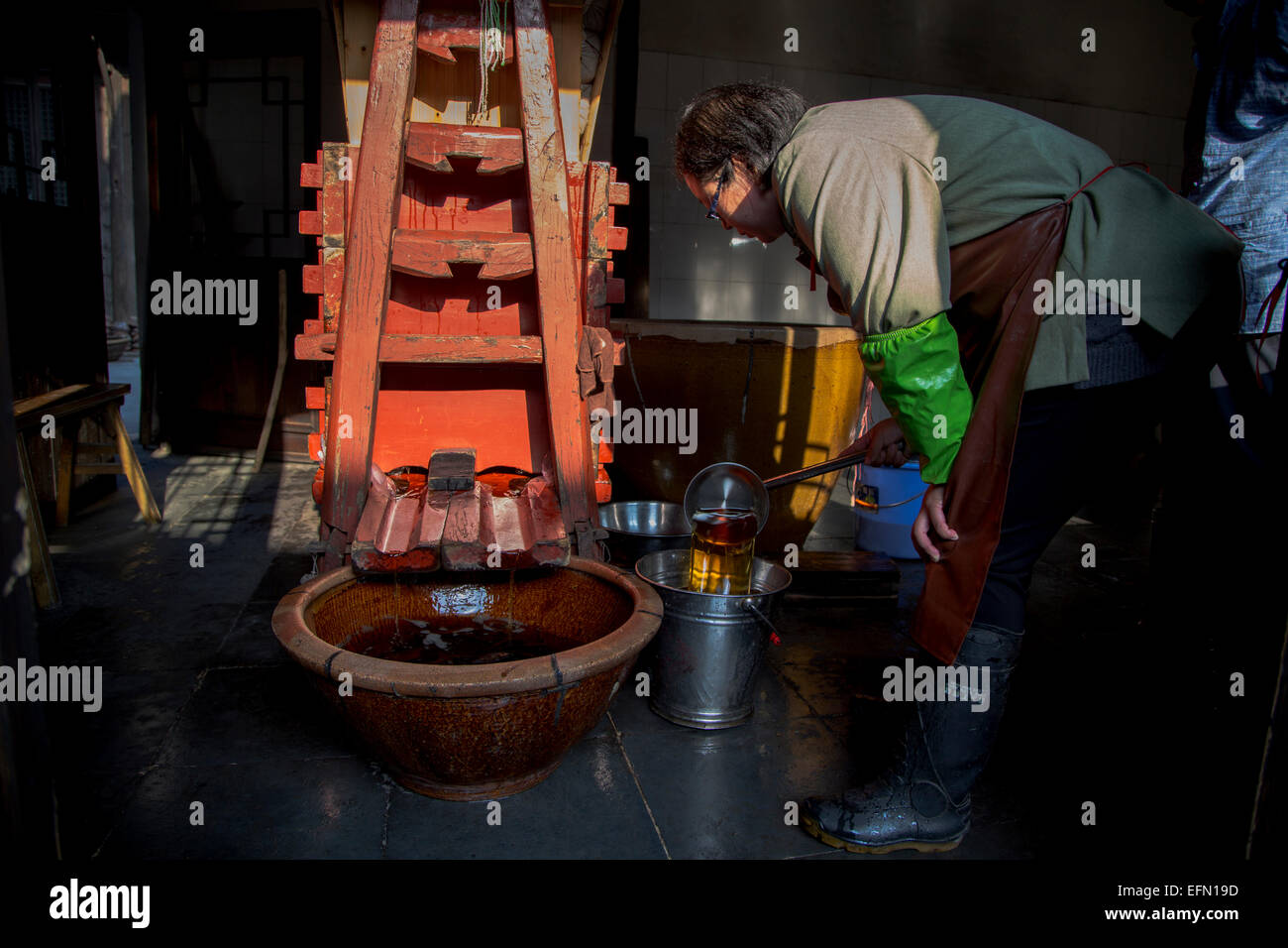traditional brewing technique of Chinese rice wine: woman is checking ...