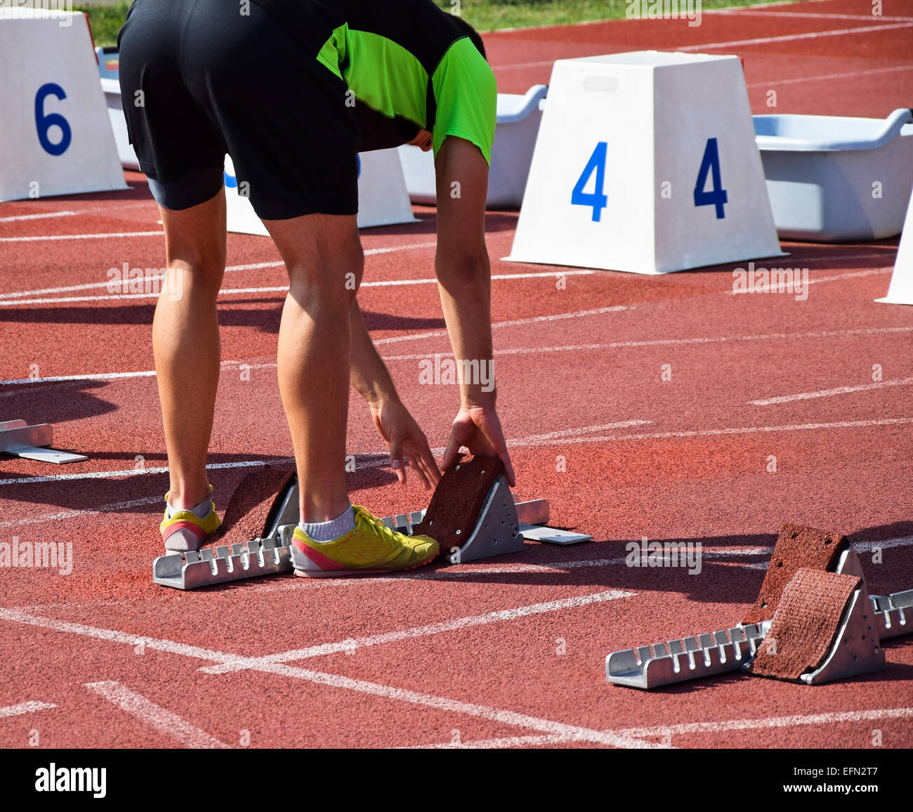 Runner at the starting line of the running track Stock Photo - Alamy