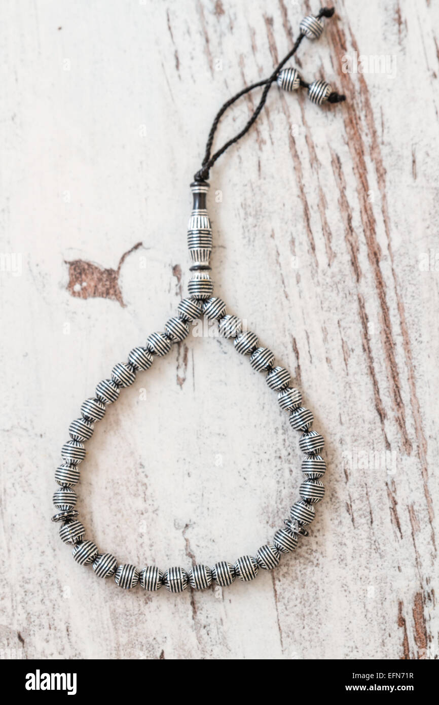 Traditional rosary from Islamic culture on white wooden background ...