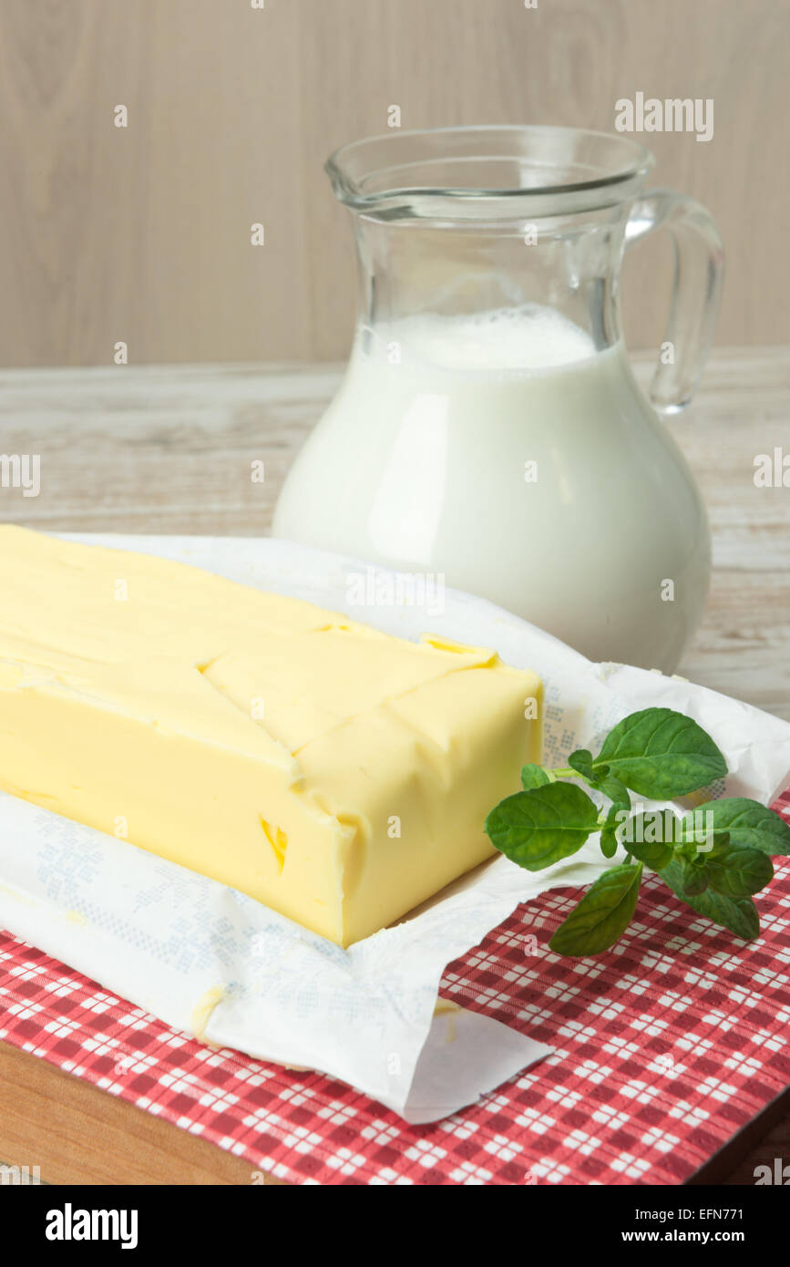 fresh butter in a bar on the table and a jug of milk Stock Photo - Alamy