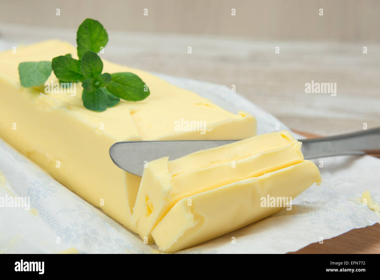 fresh butter in bar form on a table and a knife Stock Photo - Alamy