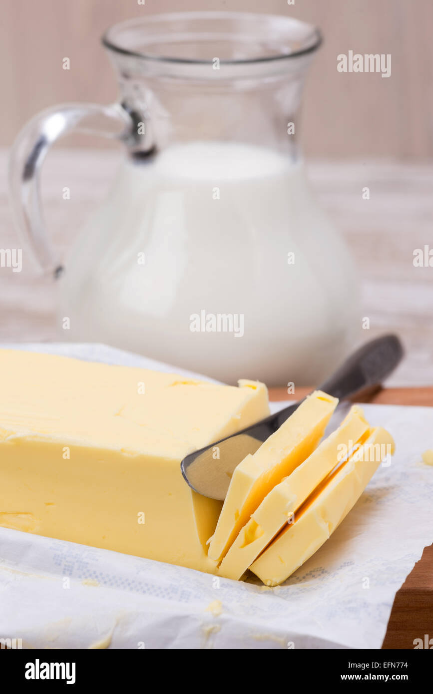 fresh butter in a bar on the table and a jug of milk Stock Photo - Alamy