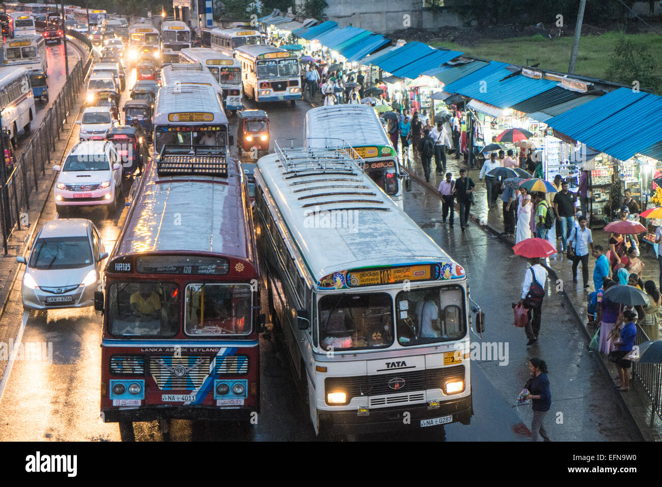 At sundown,dusk,local old Ashok-Leyland buses and cars near train ...