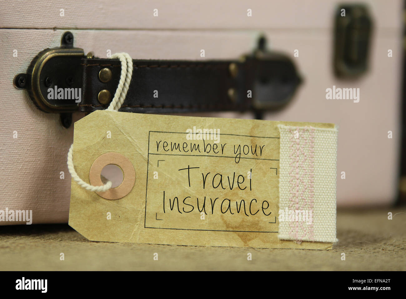 Paper tag with the handwritten words 'remember your travel insurance ...