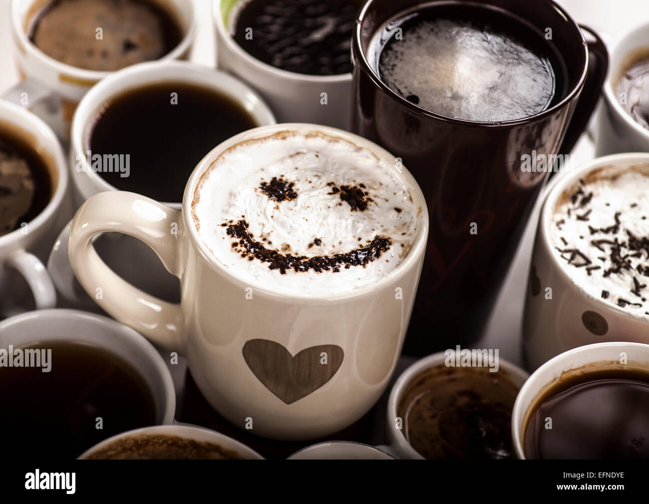 Lots of coffee in different cups with hearts and smile in one of them ...