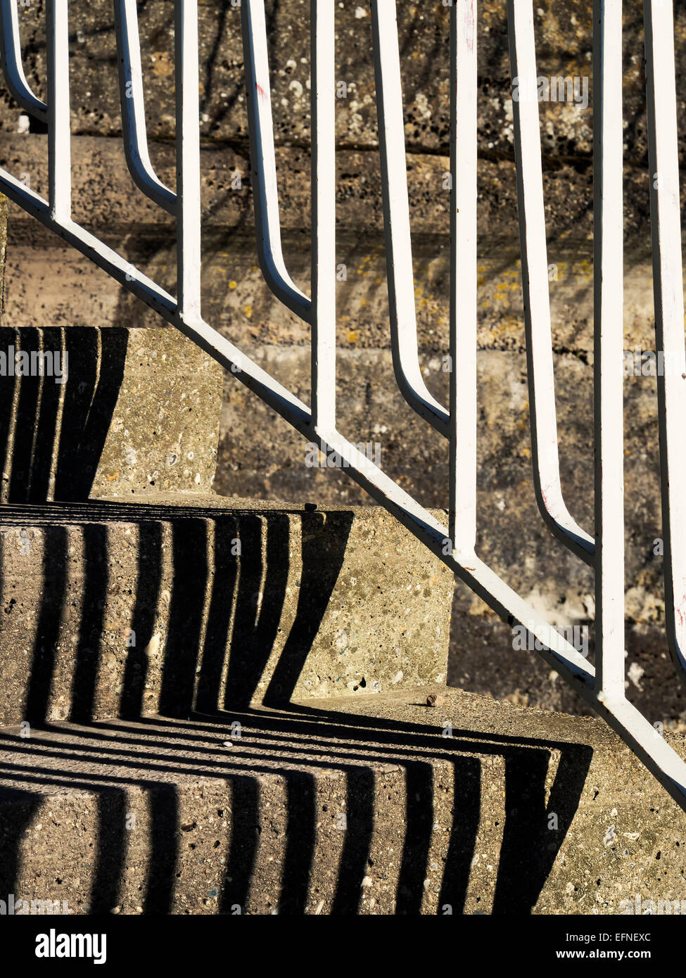 Closeup of concrete stairs with white handrail and black shadow Stock ...