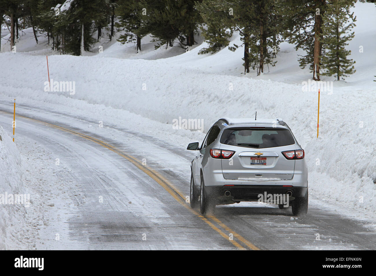 A car driving along the Northeast Entrance Road in Yellowstone National ...