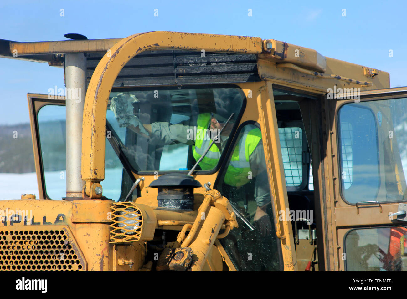 A photograph of workers cleaning windows on plow equipment in ...