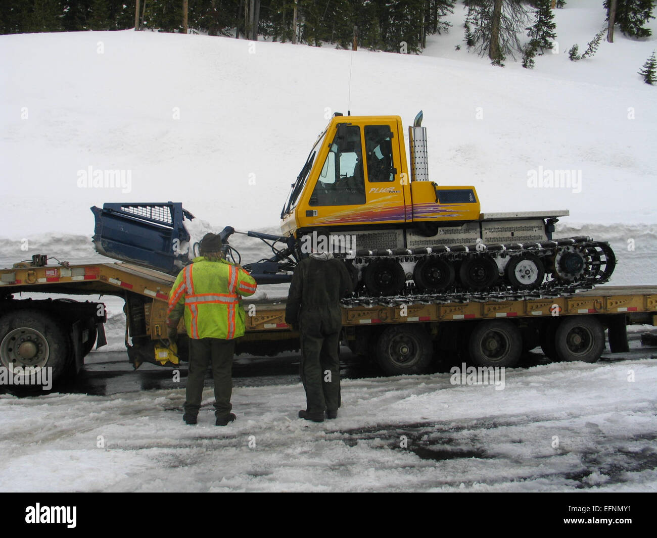 The image captures the process of loading a snow groomer for spring ...