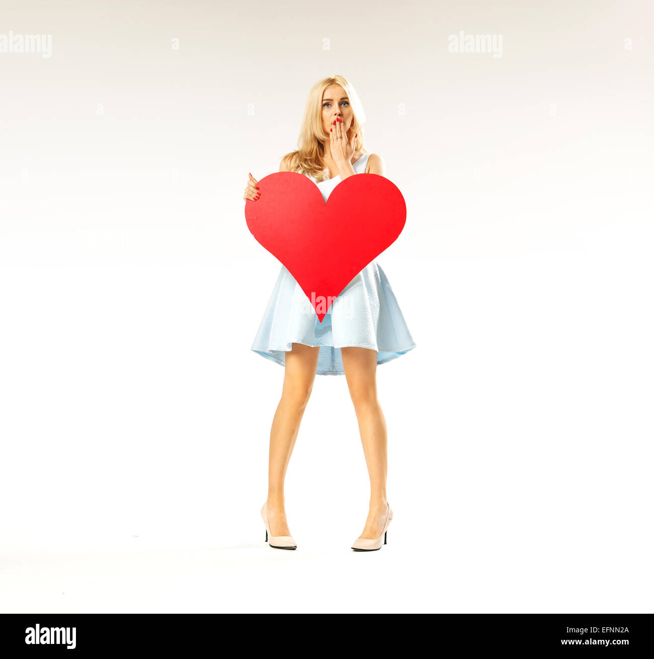 Surprised woman holding a huge heart Stock Photo - Alamy