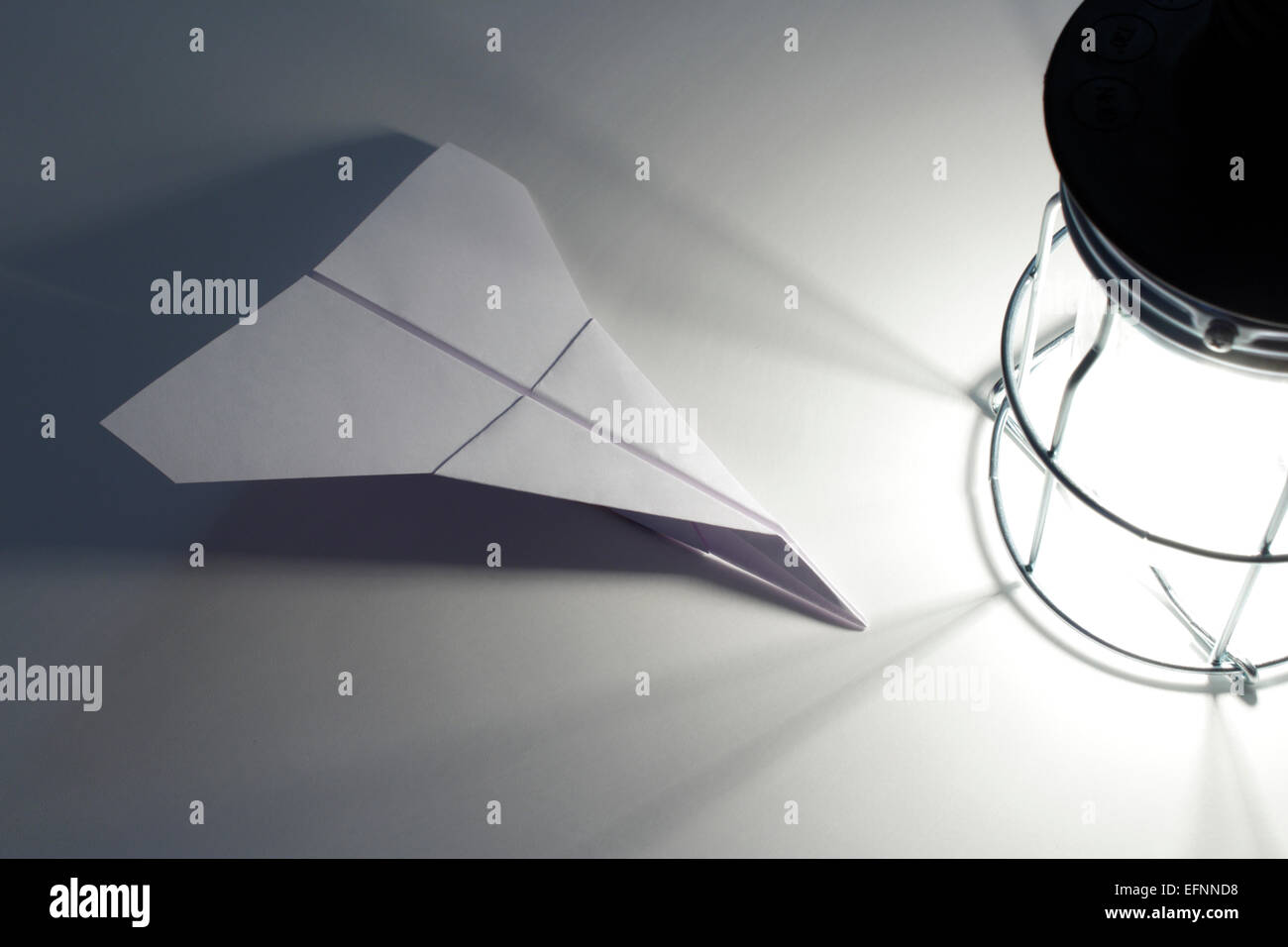 Paper plane lit by inspection lamp Stock Photo - Alamy