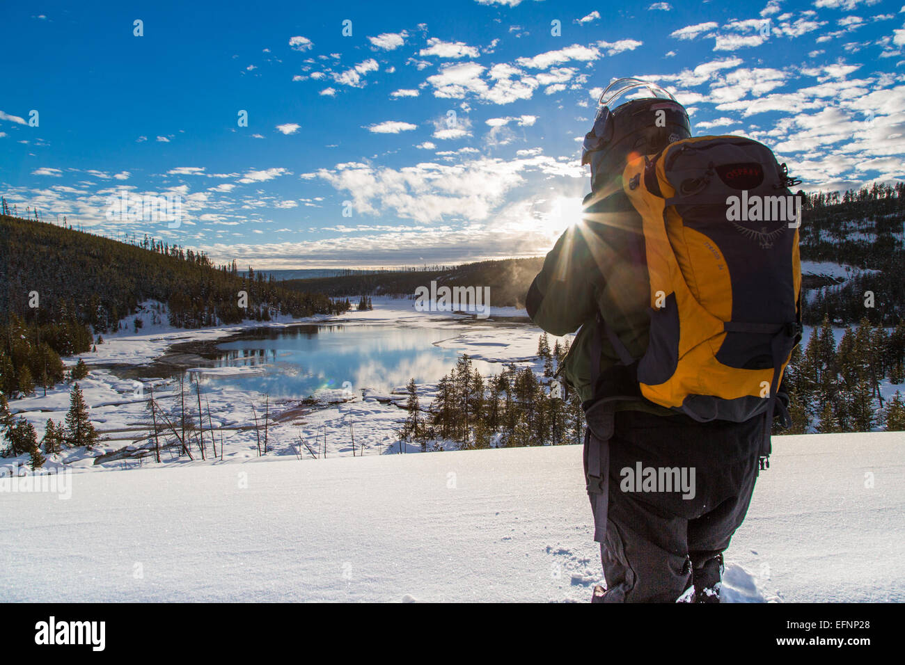 A snowmobiler captures a photograph of the setting sun over Nymph Lake ...