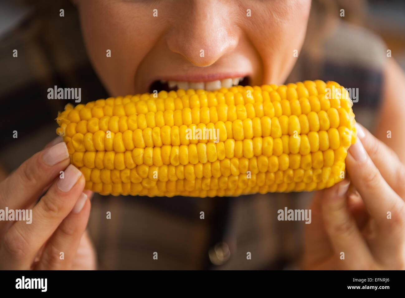 Closeup on young housewife eating boiled corn Stock Photo - Alamy