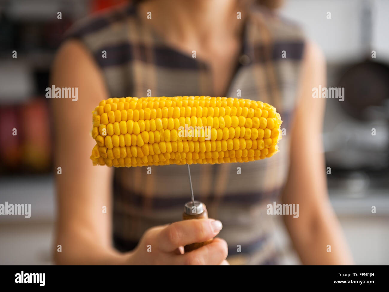 Closeup on young woman showing boiled corn Stock Photo - Alamy