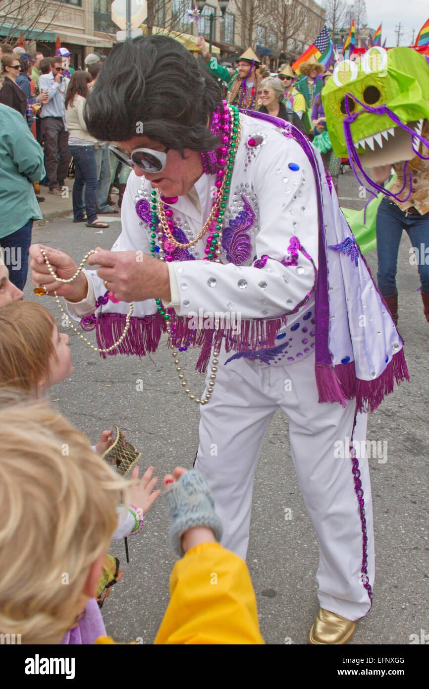 A colorful costumed Elvis character gives Mardi Gras beads to children ...