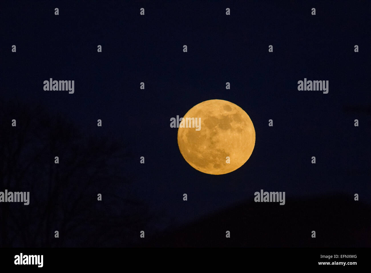A full moon rises over the rooftops of Reigate Surrey at 17.20 on ...